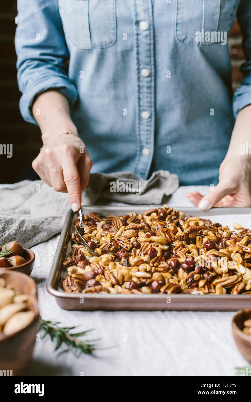 A woman is photographed from the front view as she is mixing nuts to ...