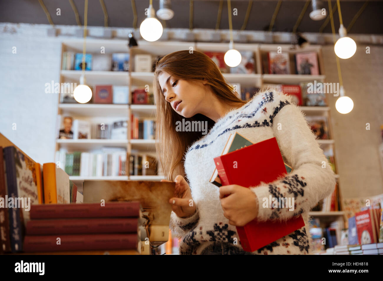 Portrait of a pretty young woman choosing books in library Stock Photo ...