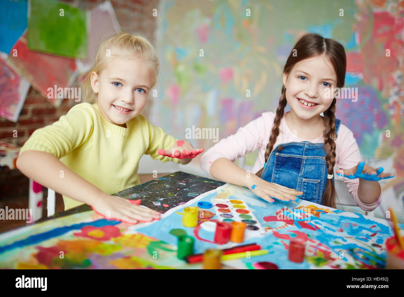 Cute schoolgirls having fun at drawing lesson Stock Photo - Alamy