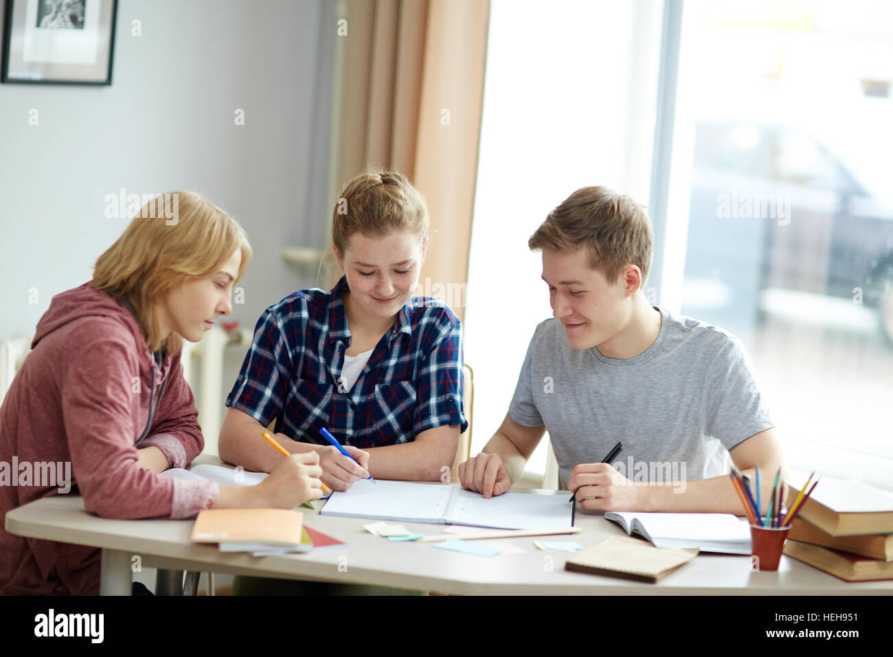 Young students doing assignment together Stock Photo - Alamy