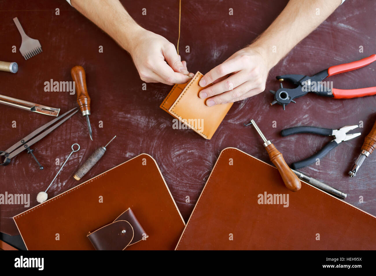Human hands using handtool while producing leather item Stock Photo - Alamy