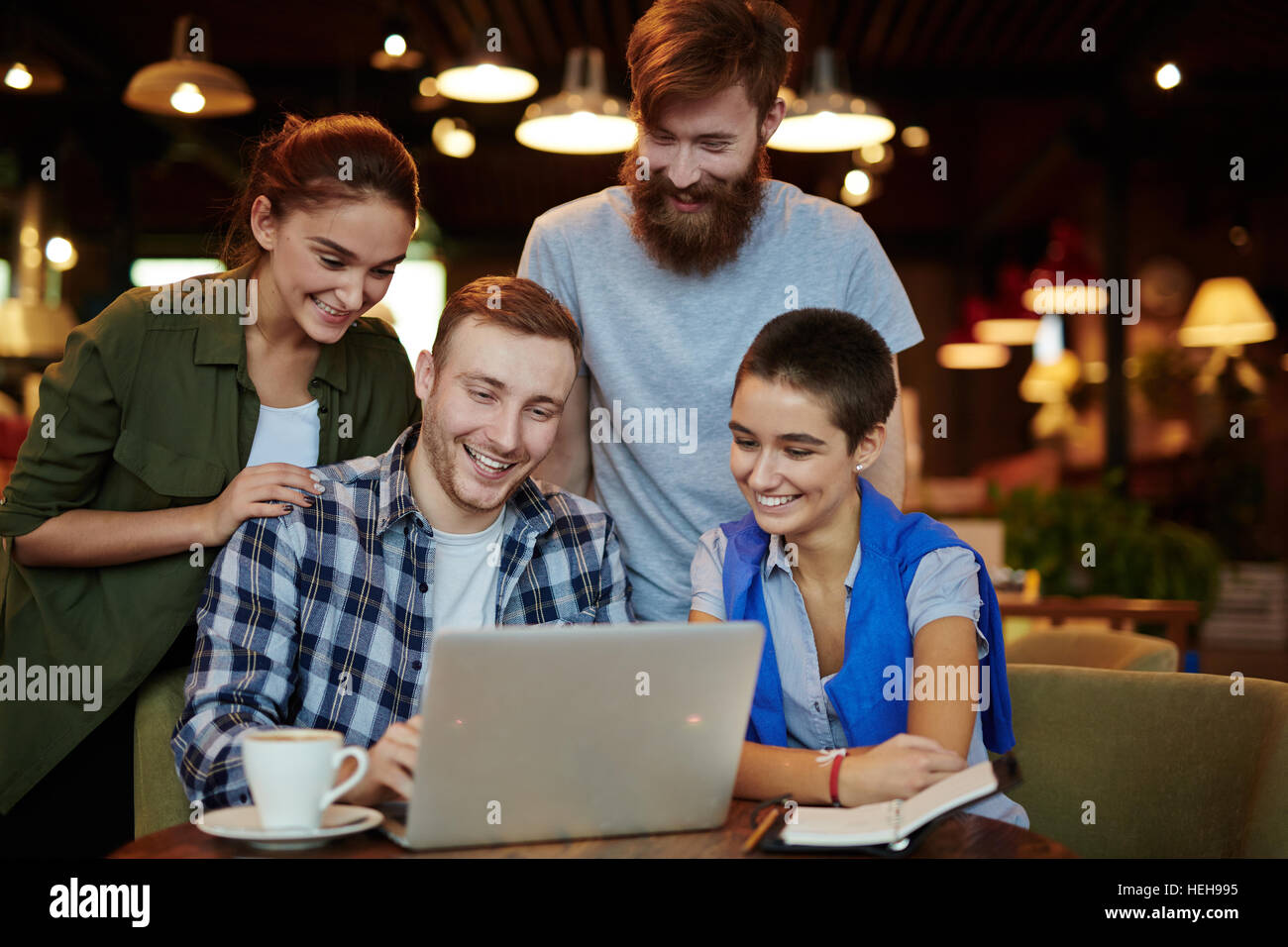 Happy friends with laptop watching something interesting online while ...