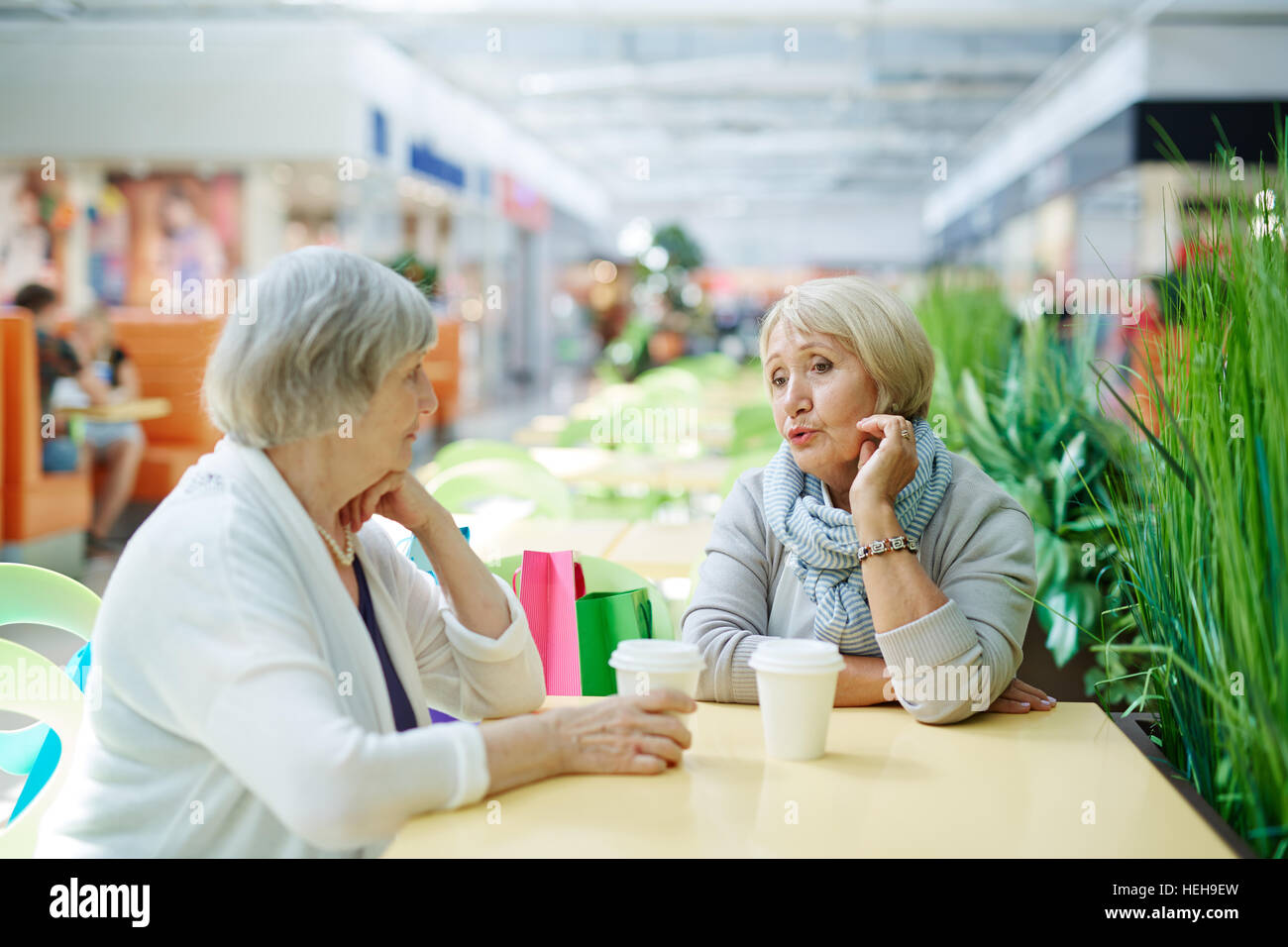 Restful females having drinks and conversation after shopping Stock ...