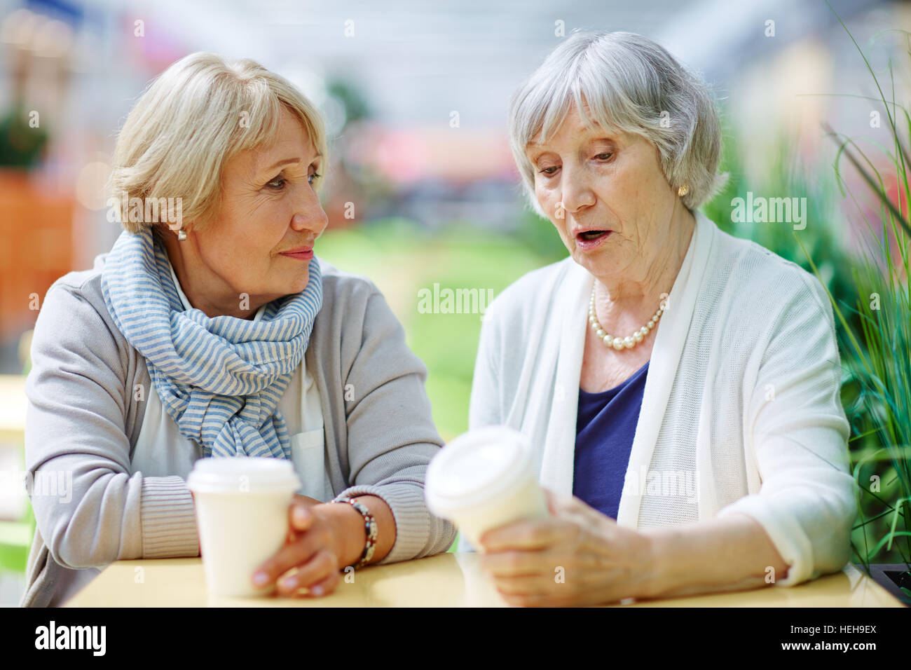 Two grannies relaxing by cup of coffee in cafe Stock Photo - Alamy