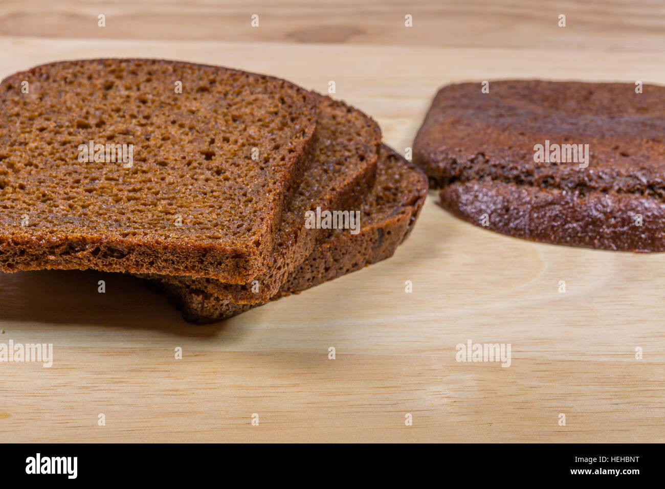 Pieces Of Sliced Brown Bread On Wood Stock Photo - Alamy