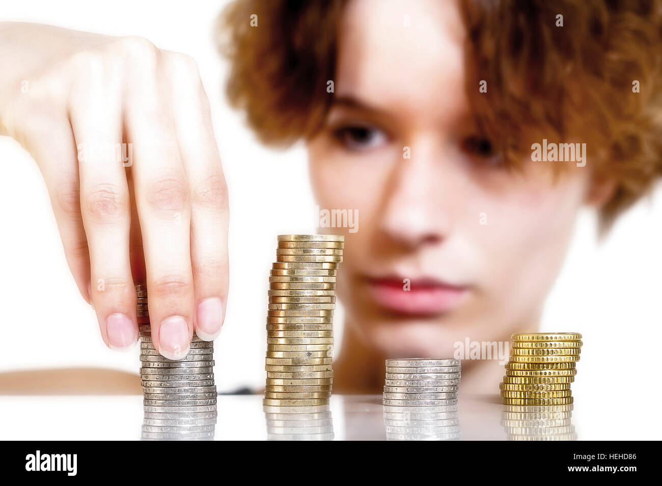 Young woman stacking coins Stock Photo - Alamy
