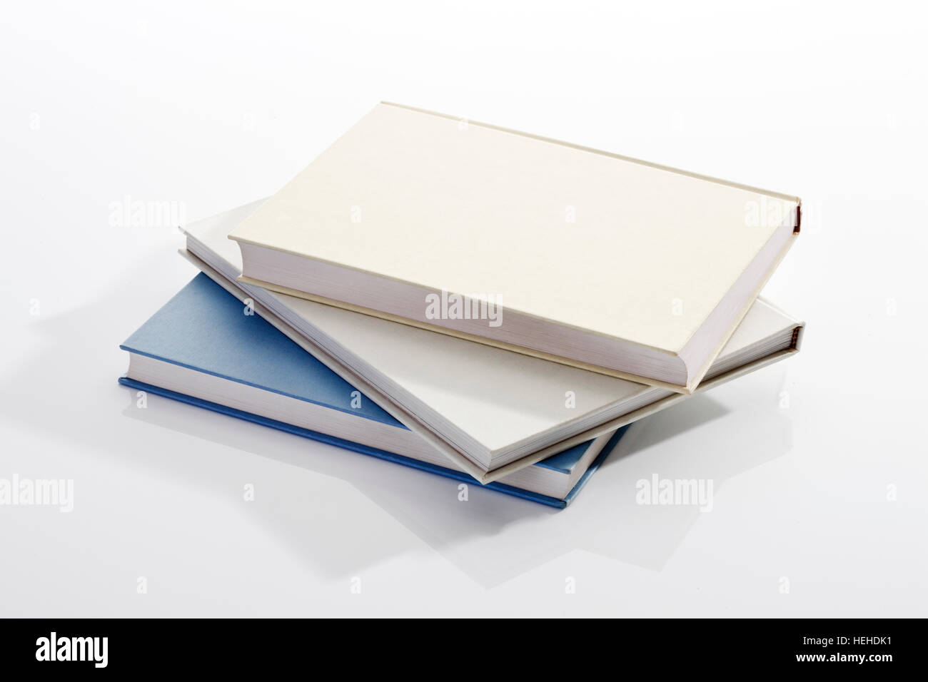 Three stacked hardcover books, blank unprinted covers with no dust ...