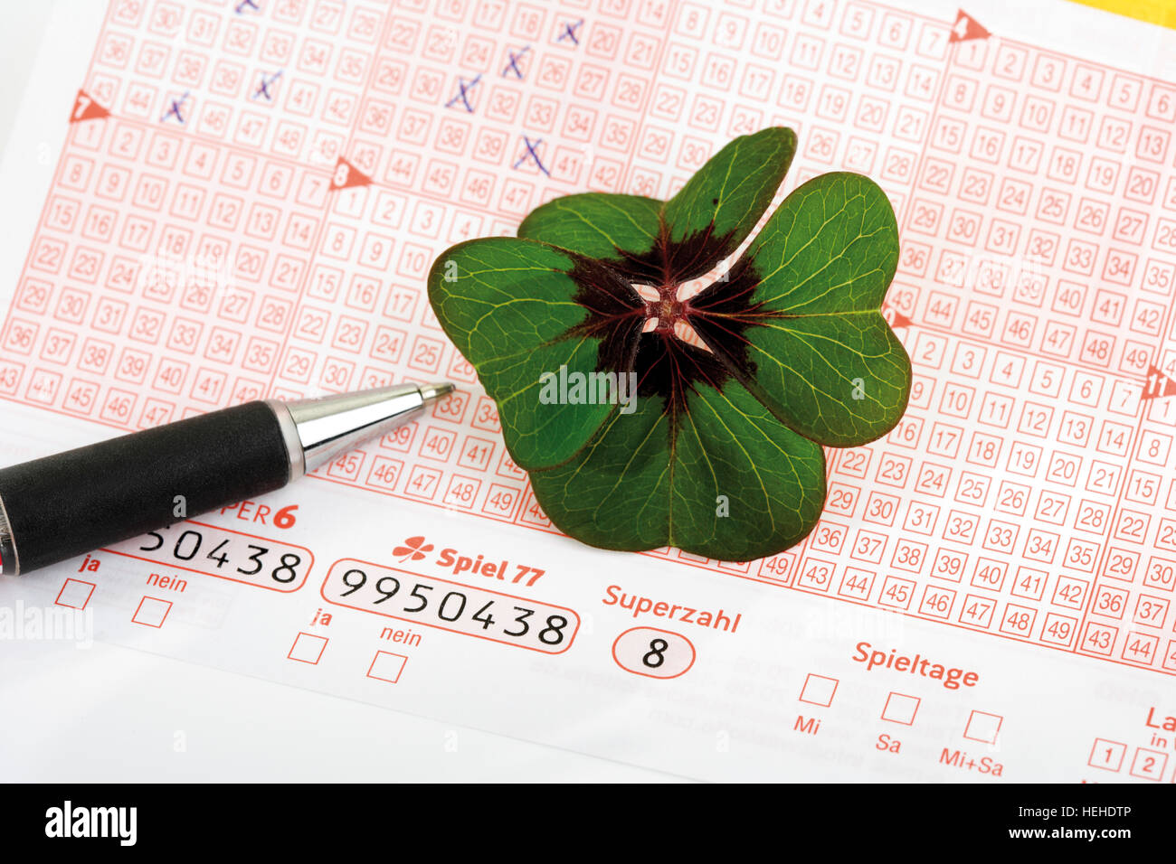 Lottery ticket with pen and four-leaf clover Stock Photo - Alamy