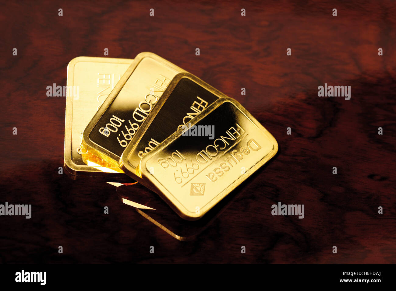 Gold bars on a mahogany table Stock Photo - Alamy