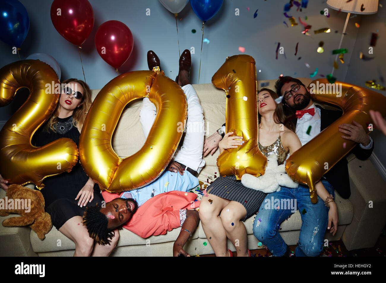 Tired friends sleeping on couch after new year party Stock Photo - Alamy