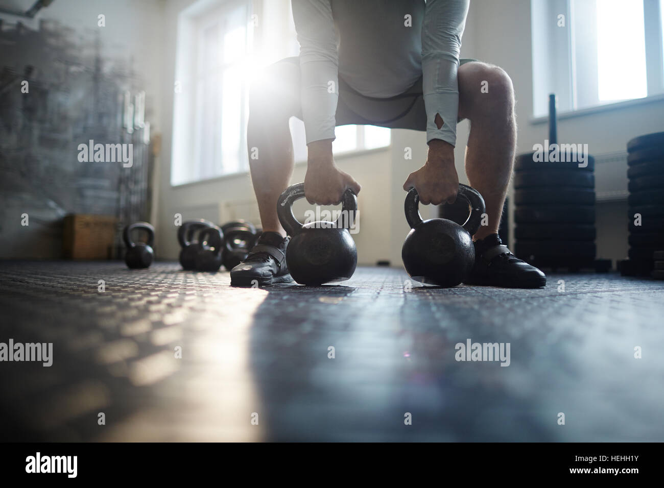 Strong athlete lifting heavy kettlebells Stock Photo - Alamy
