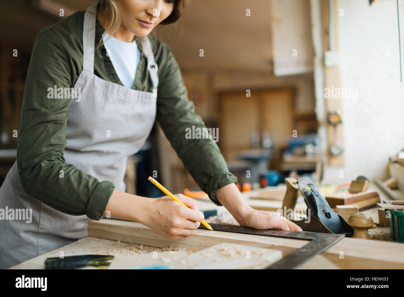Female cabinetmaker measuring wooden plank Stock Photo - Alamy