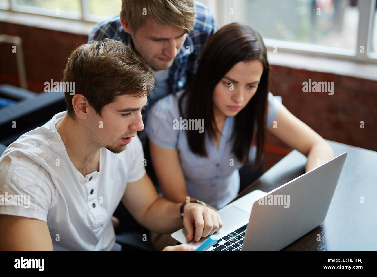Friendly students looking through information online Stock Photo - Alamy