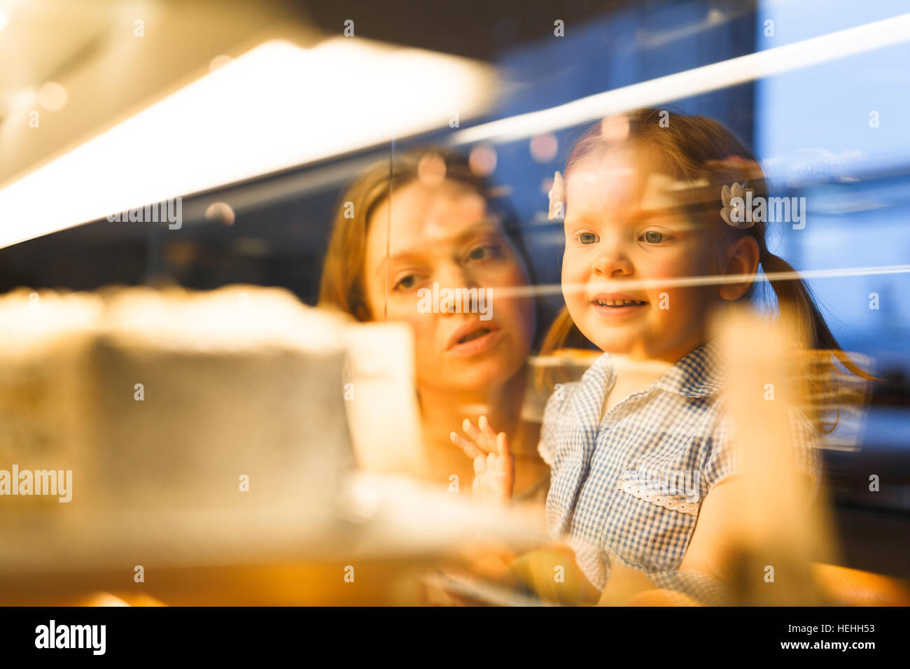 Pretty little girl looking at something in shop window Stock Photo - Alamy