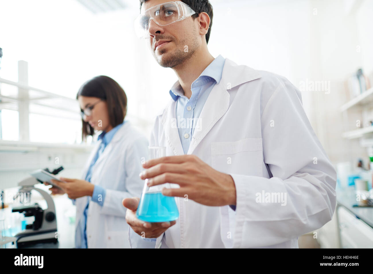 Young chemist with tube working in laboratory Stock Photo - Alamy