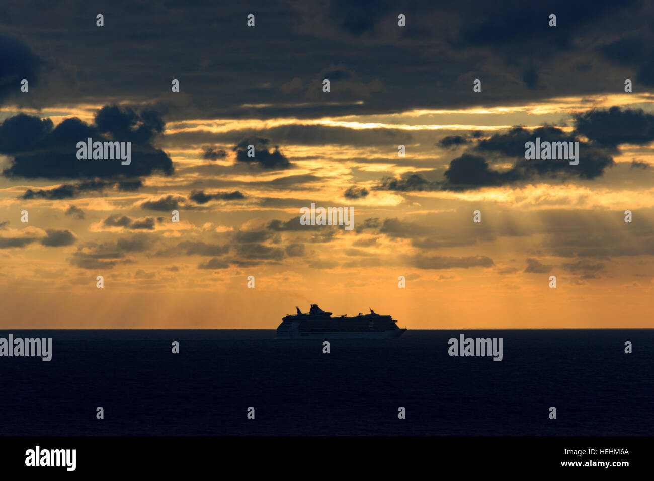 Cruise ship sailing in the atlantic ocean with sun rays coming from ...