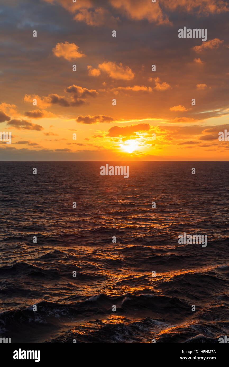 Sunset over ocean with reflection of sun on waves of atlantic ocean ...