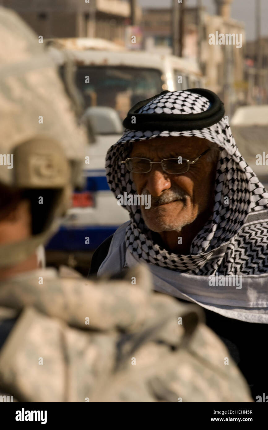 An Iraqi man walks by an U.S. Army Soldier of the 21st Military Police ...