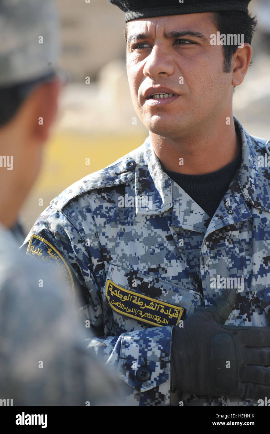 An Iraqi national policeman talks with U.S. Soldiers of F Company, 2nd ...