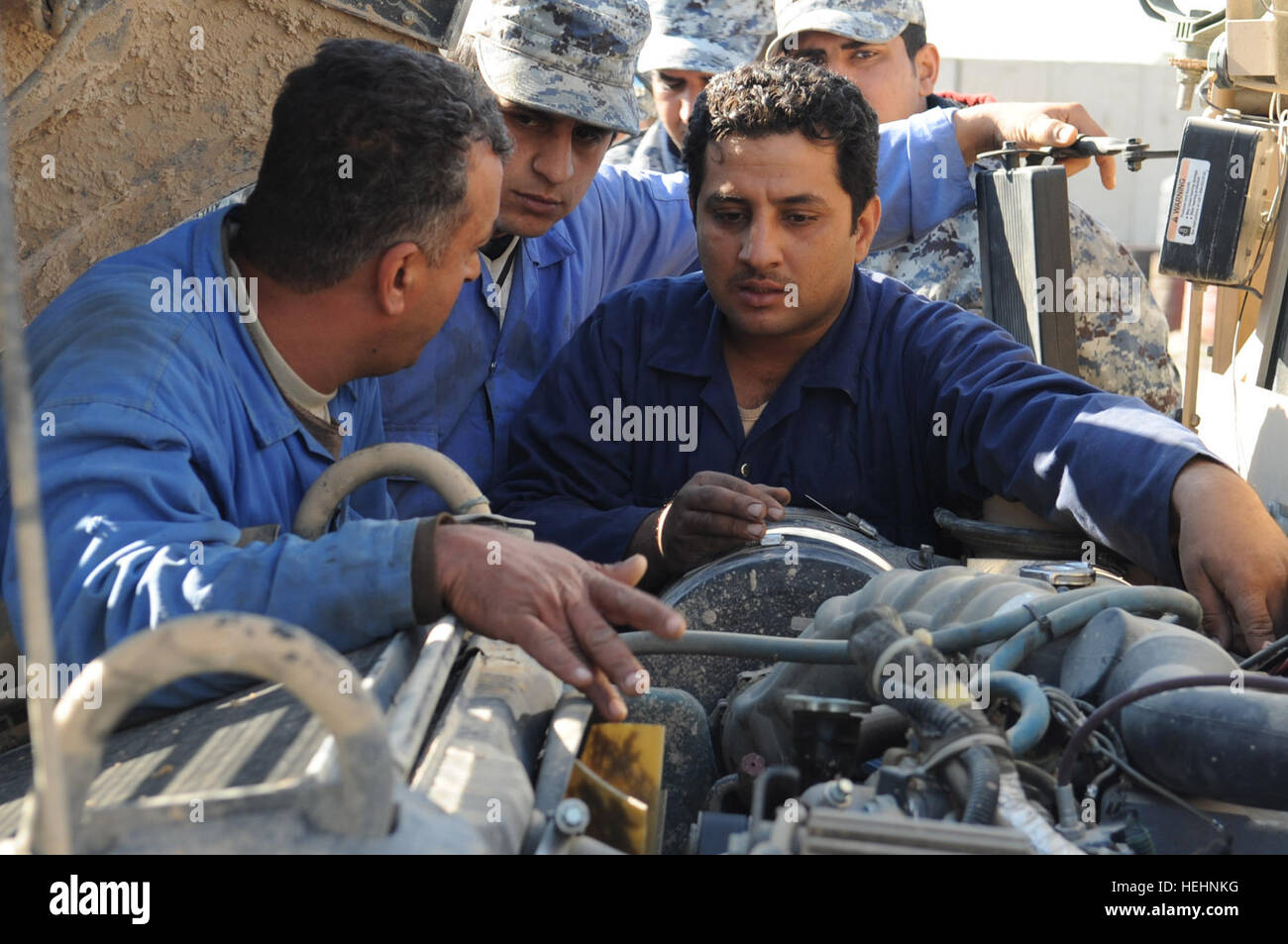 Iraqi National Police mechanics examine the engine compartment of a ...