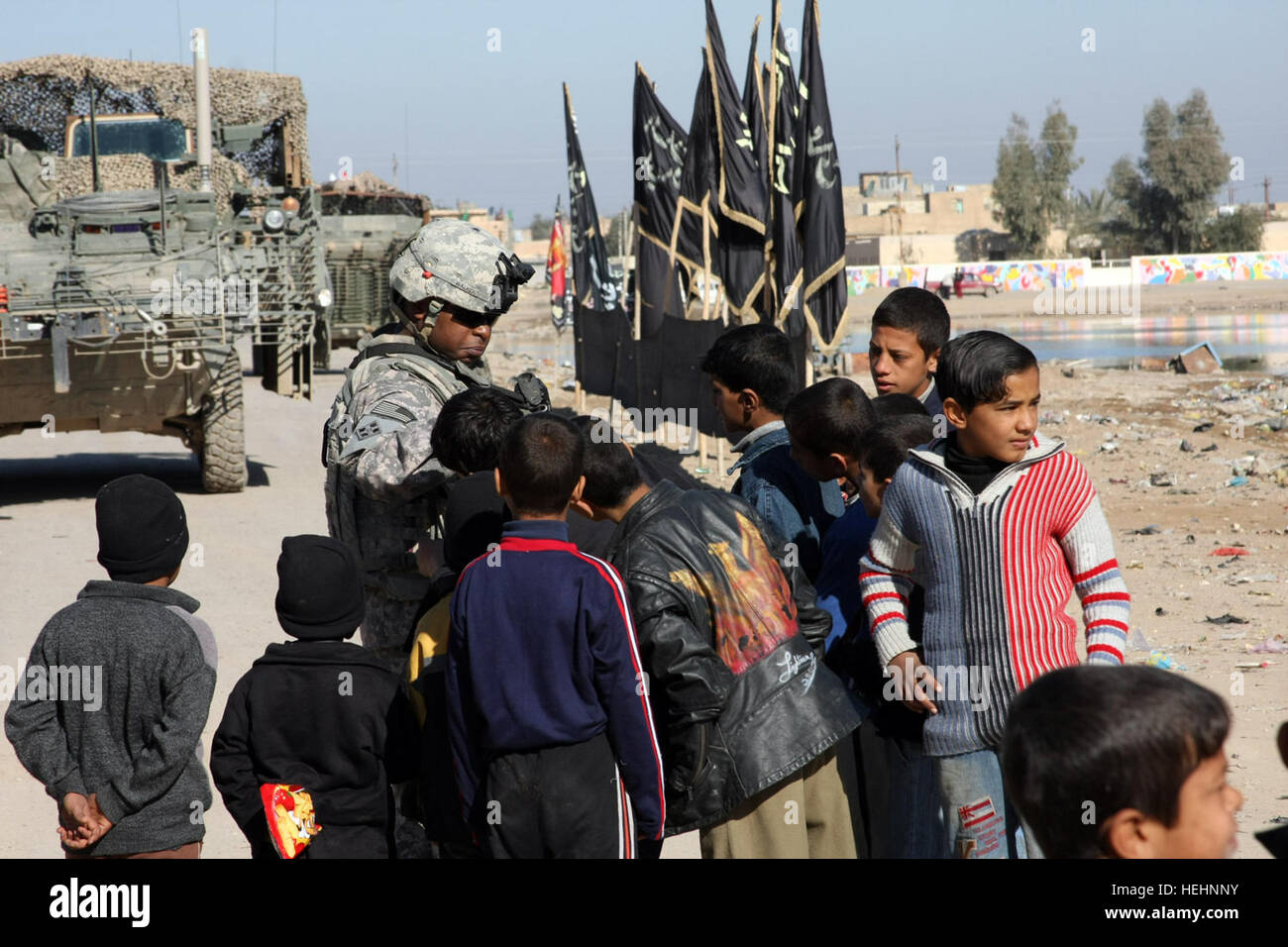 Sgt. 1st Class Dion Walker, of Louisville, Ky., gives candy to children ...