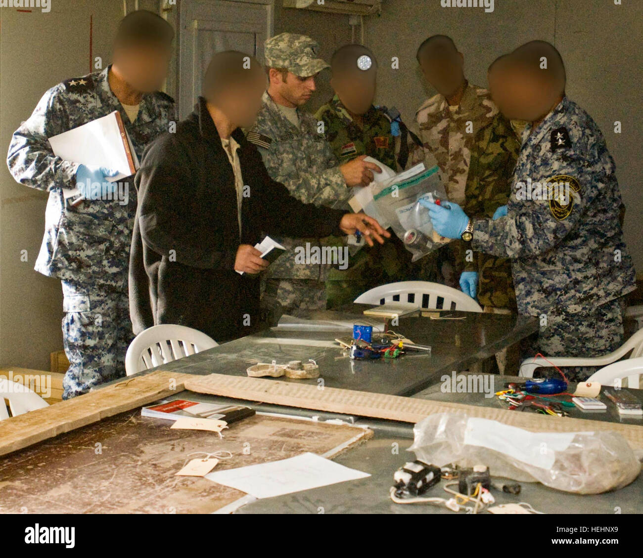 Iraqi soldiers and police officers work together to find clues in a ...