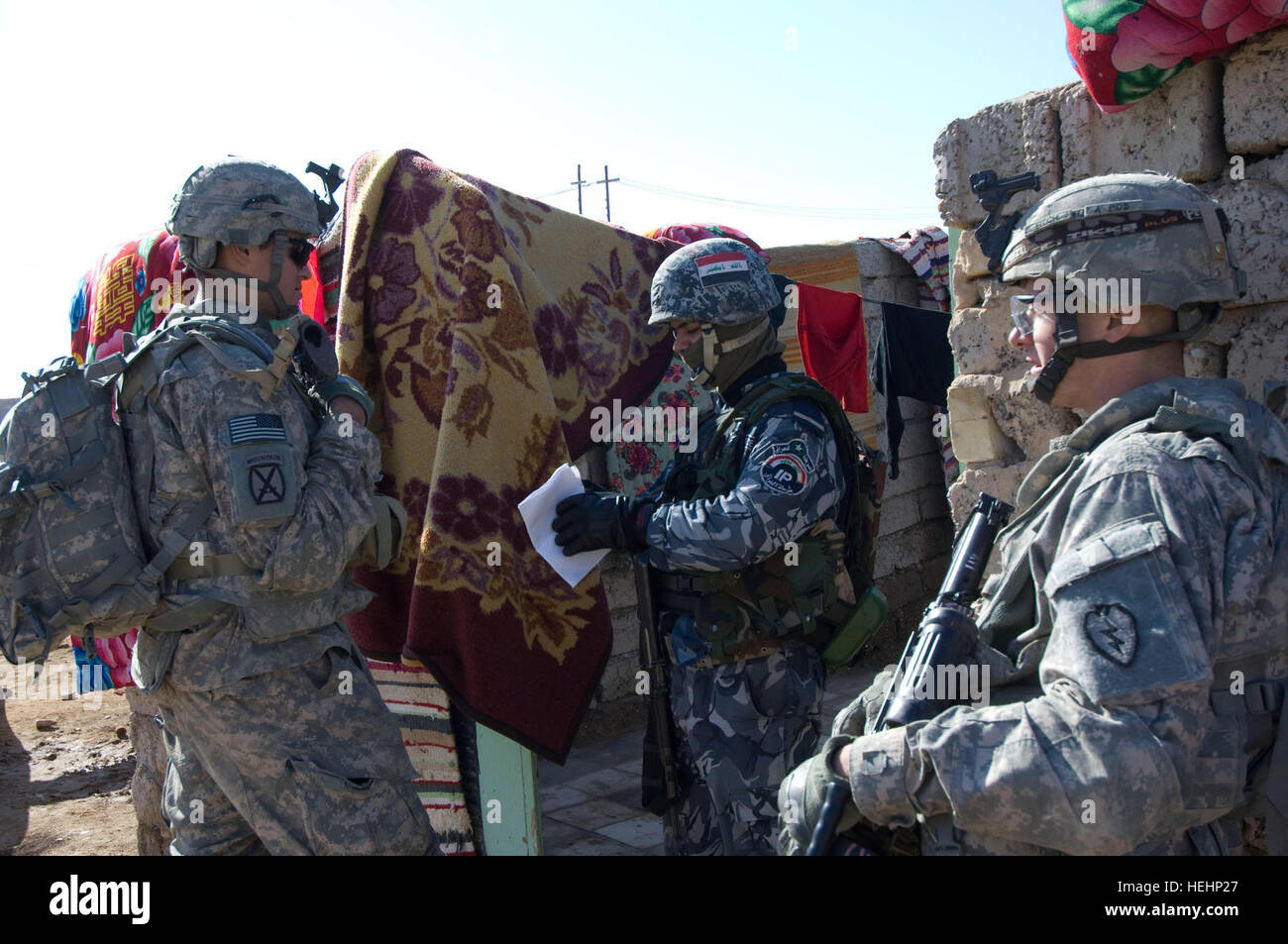 An Iraqi policeman shows U.S. Army Spc. Peter Parra (left ...
