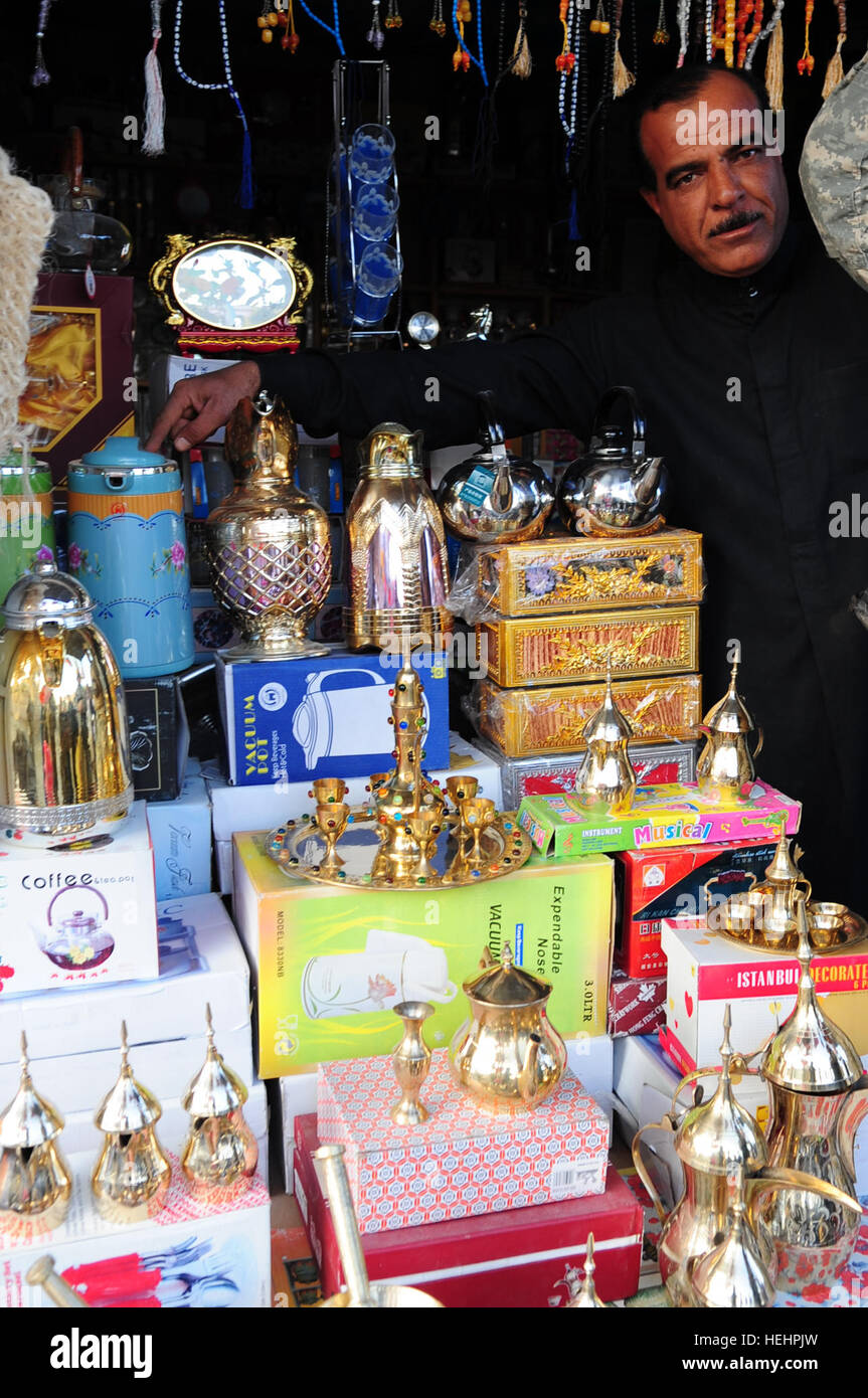 An Iraqi man shows off the items in his store as U.S. Soldiers from ...