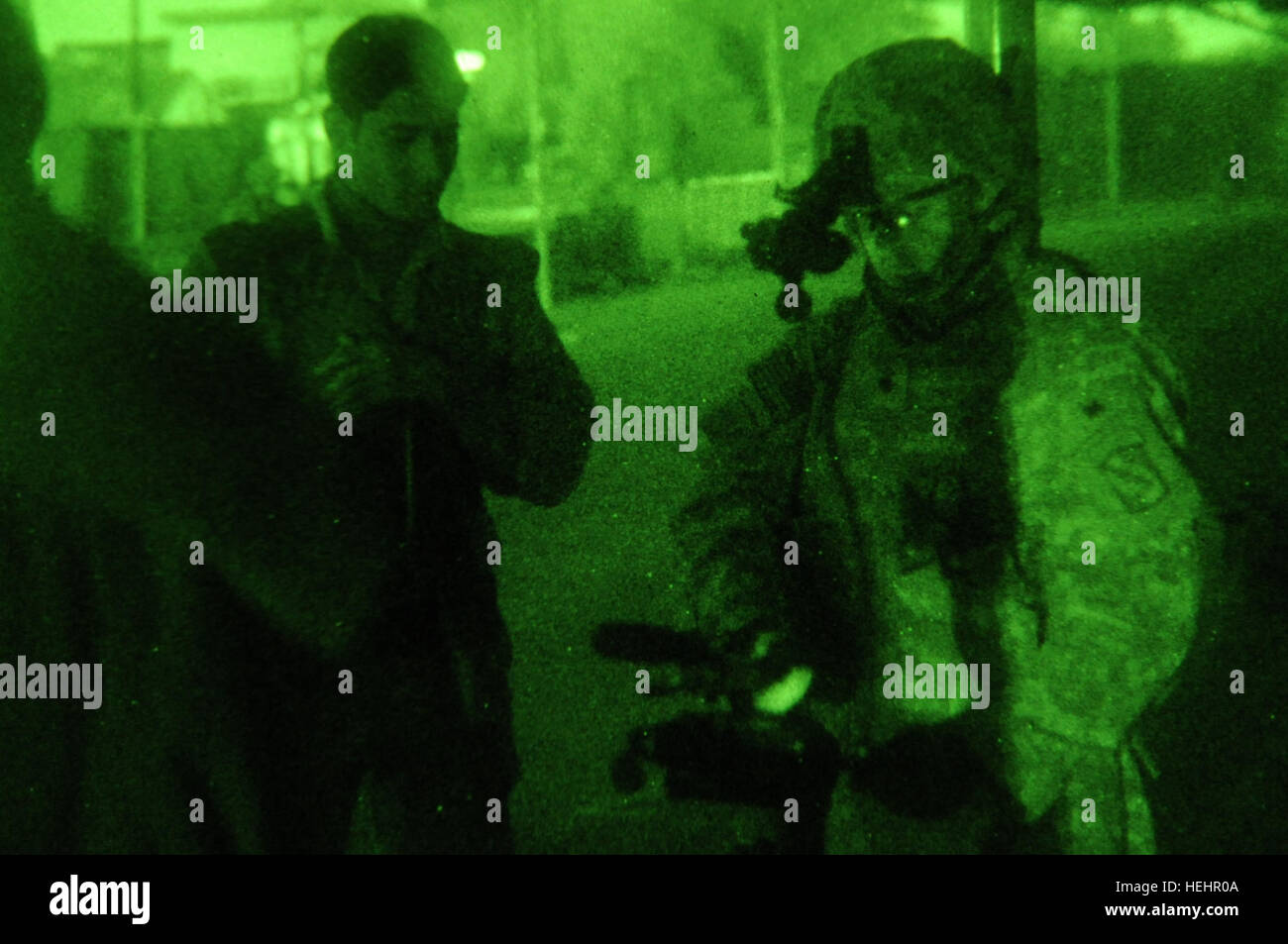 An Iraqi policeman watches as U.S. Army Spc. Joshua Lowery from Senoia ...