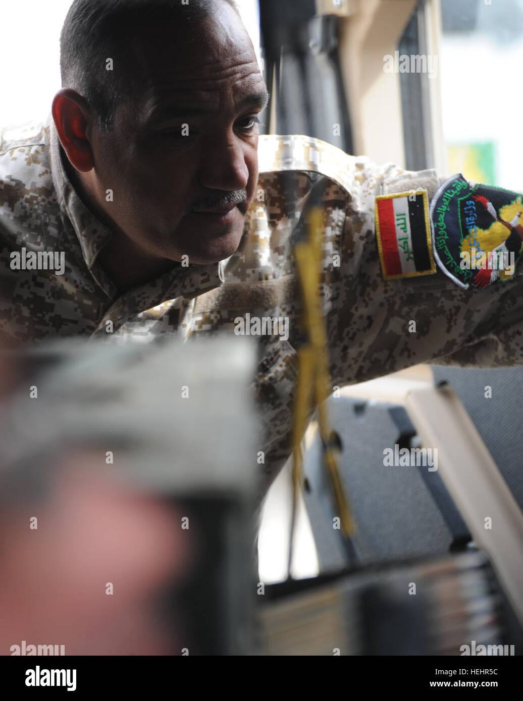 An Iraqi soldier looks in on Humvee mechanic's training, conducted by U ...