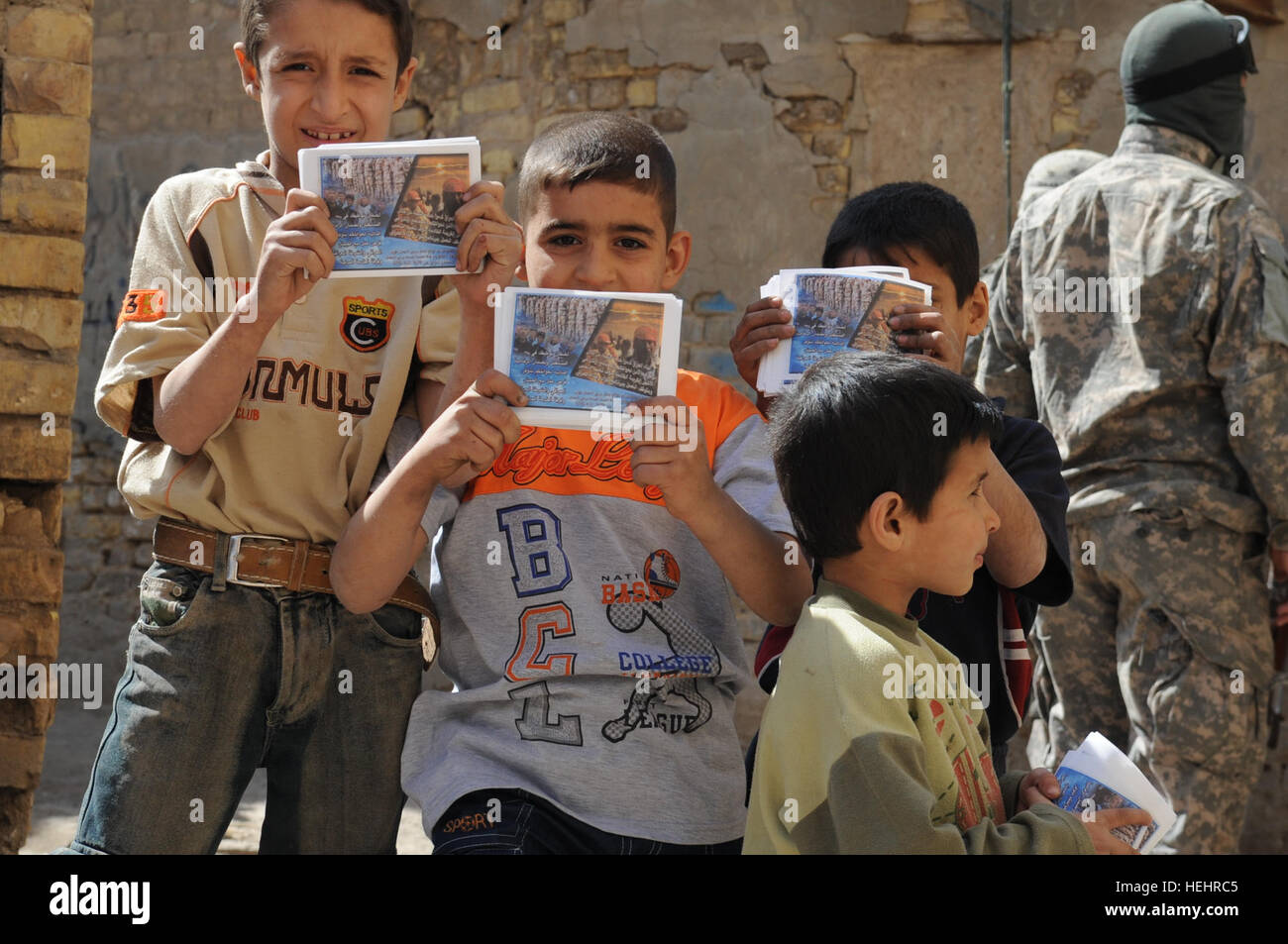 Iraqi boys hold up handbills given to them by Iraqi Soldiers during a ...