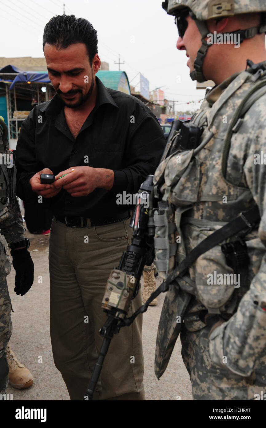 An Iraqi man talks to U.S. Army Capt. Mathew Laclair (right) from ...