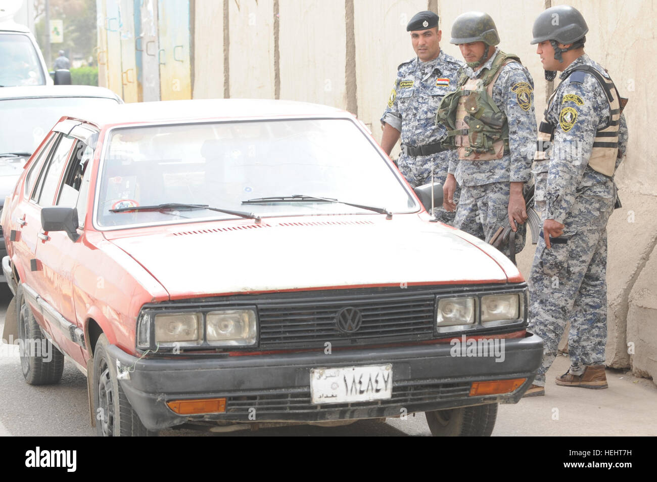 Iraqi national police stop a vehicle while U.S. Soldiers observe, at a ...