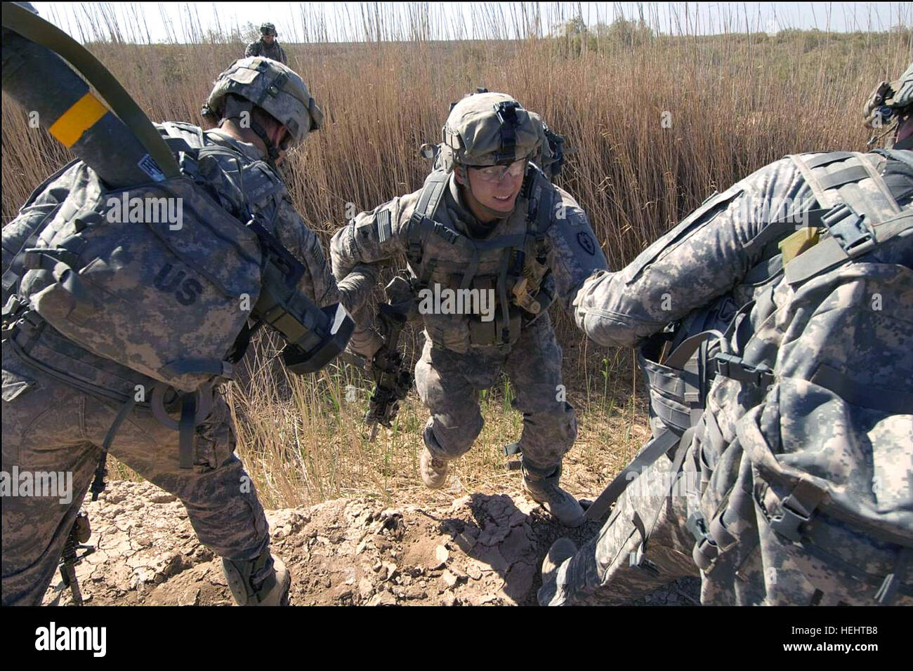 U.S. Army Sgt. Shane Fackrell gets a hand climbing up a canal ...