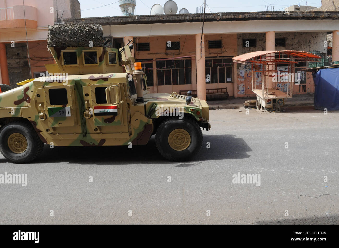 An Iraqi Humvee moves down a mostly deserted street at the scene of ...