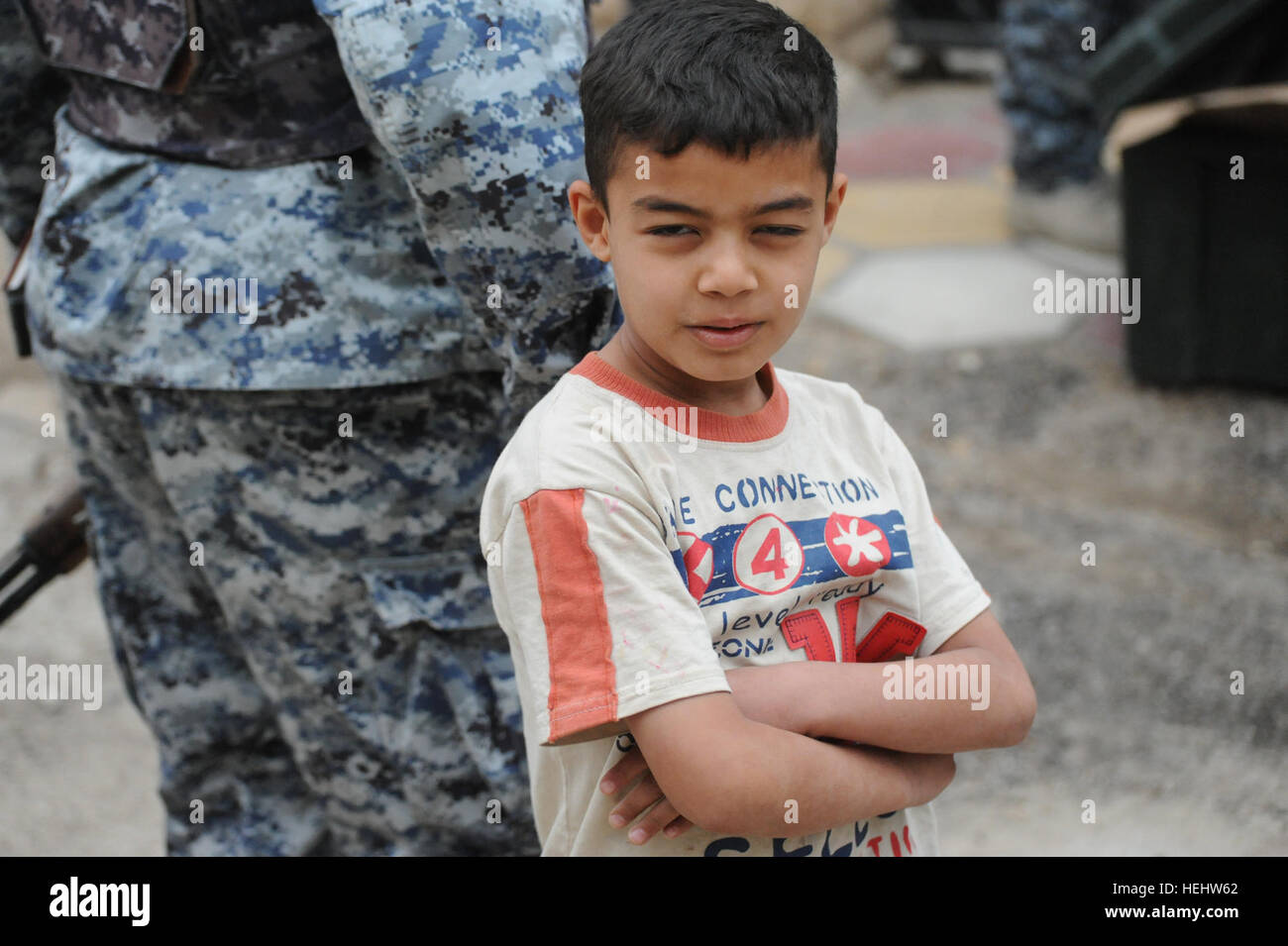 A local Iraqi boy squints at the camera while Iraqi national police of ...