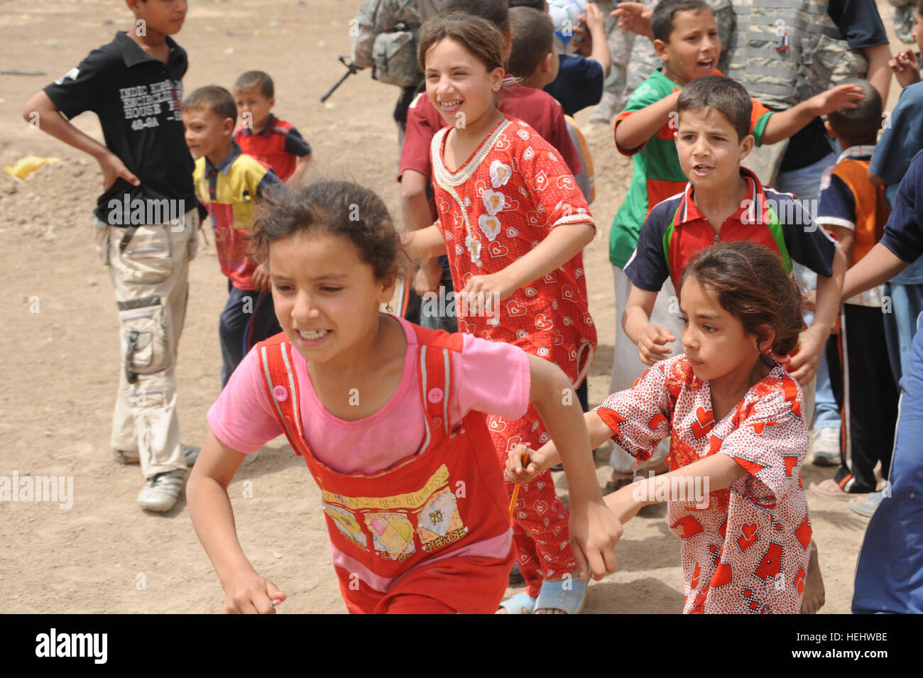 Iraqi children run to play soccer with the donated soccer ball they ...