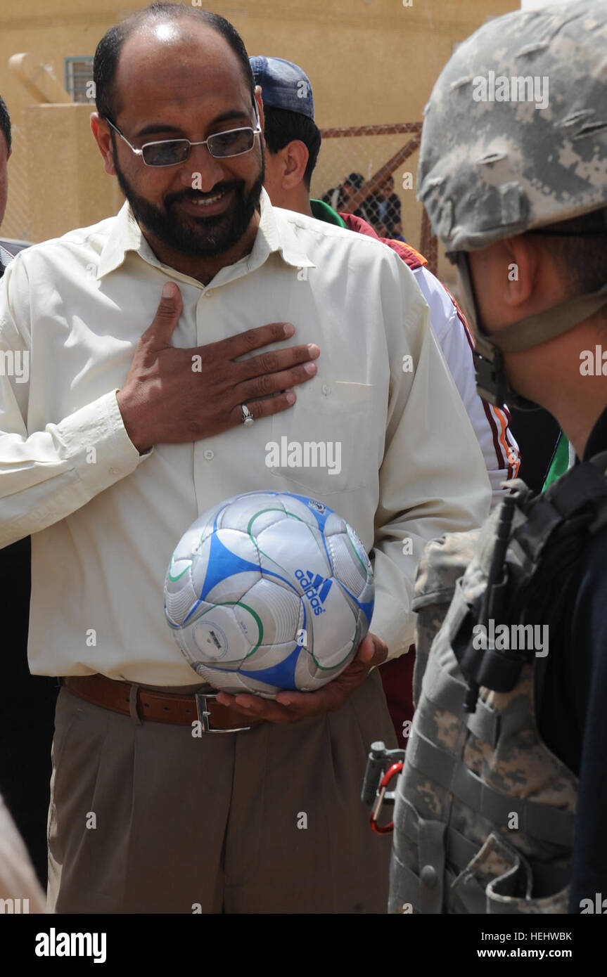An Iraqi official accepts a soccer ball presented by U.S. Army Lt. Col ...