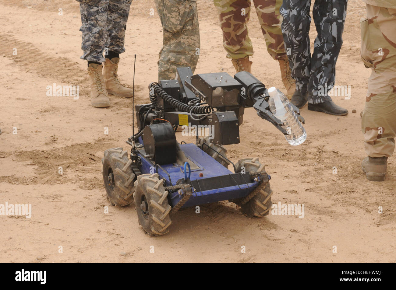 An explosive ordnance remote control robot carries a bottle of water ...