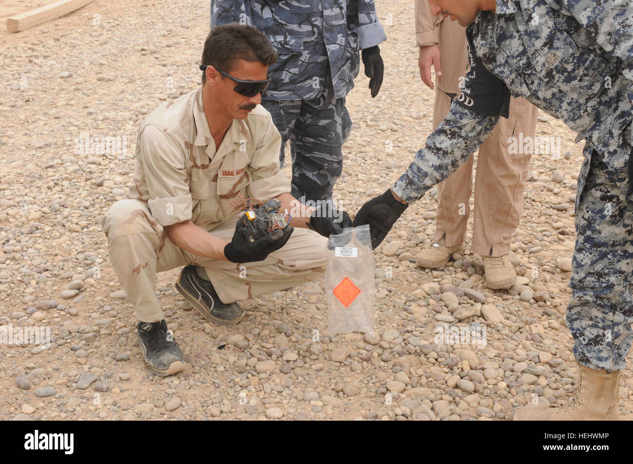 A member of the Iraqi police counter explosive places a simulated ...