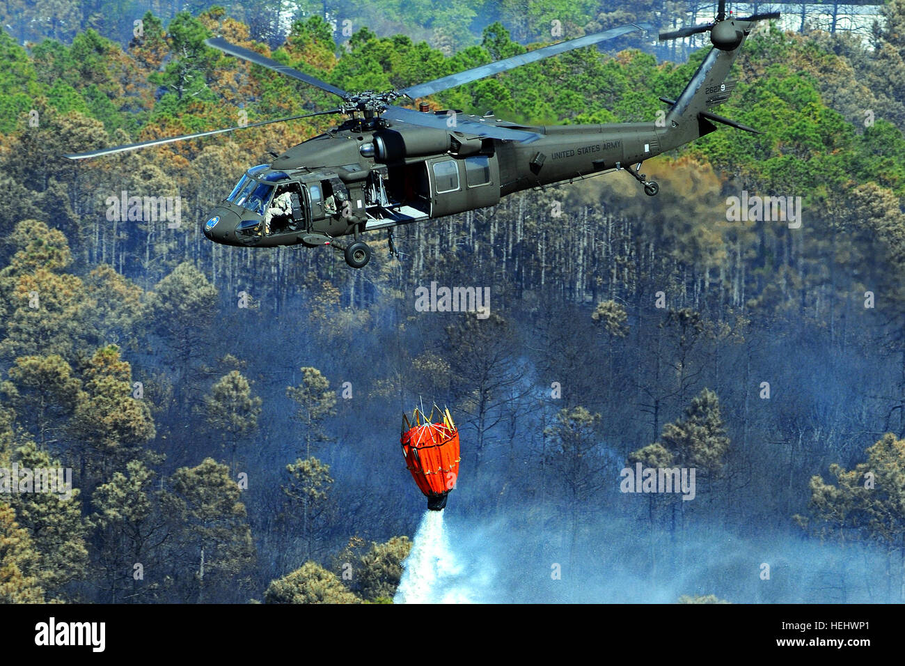 A U.S. Army UH-60 Blackhawk helicopter drops 600 gallons of water onto ...