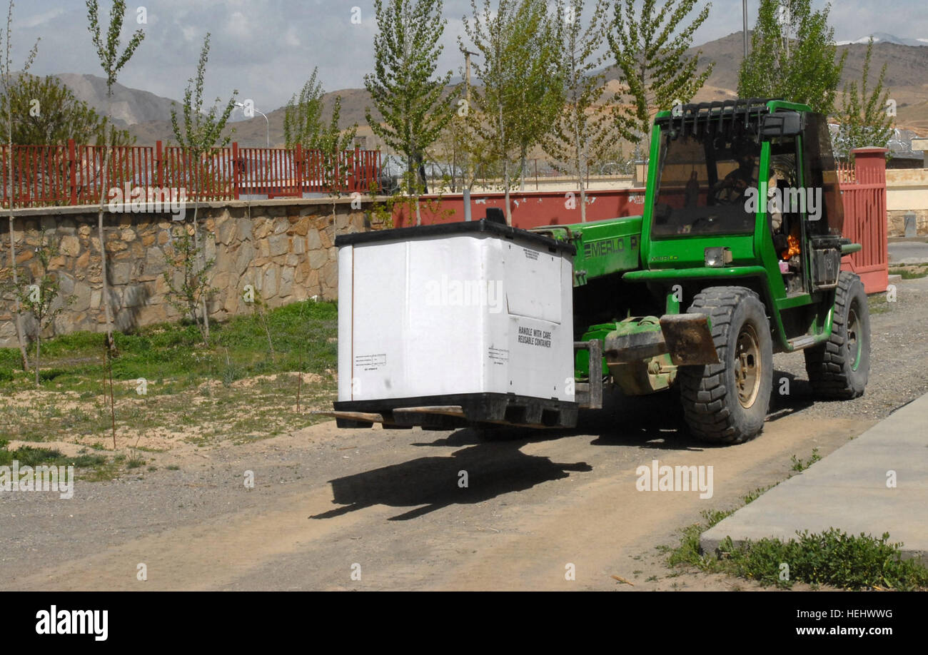 A forklift dropping off humanitarian aid rumbles along the road beside ...