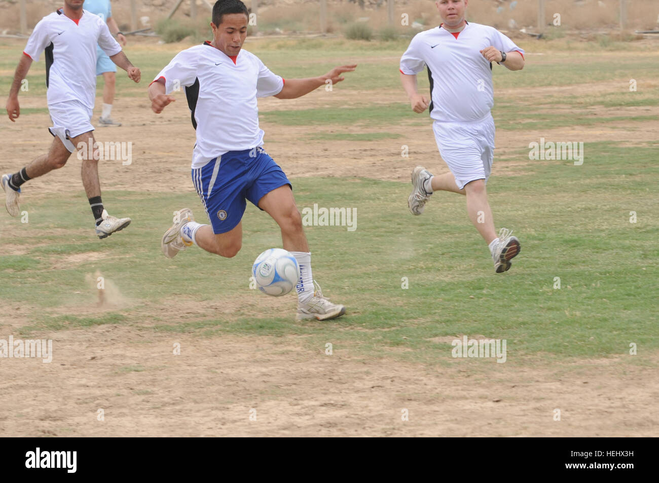 Members of a joint Iraqi and U.S. soccer team maneuver the ball down ...