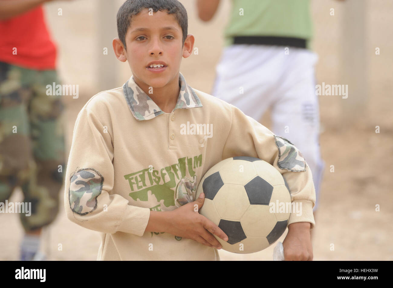 An Iraqi boy holds a soccer ball in Karadah, eastern Baghdad, Iraq on ...