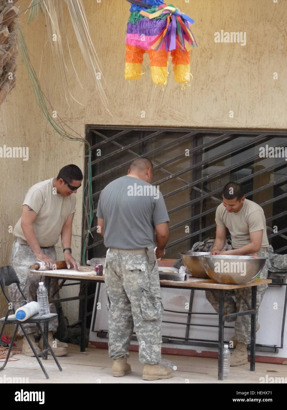 A colorful pinata hangs above Soldiers from the 277th Engineer Company ...