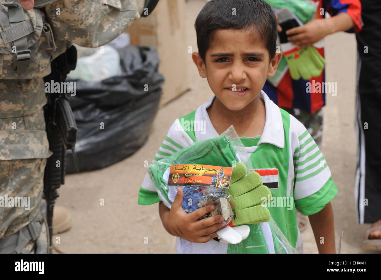 An Iraqi boy holds toys, gloves and a soccer shirt given to him by U.S ...