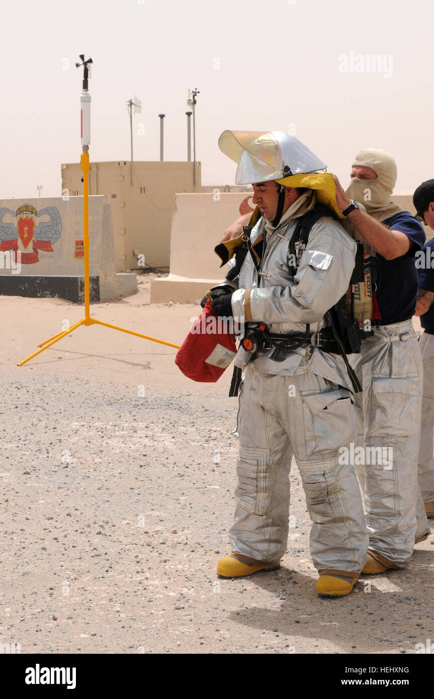 A contracted firefighter dons his gear during a simulated chemical ...