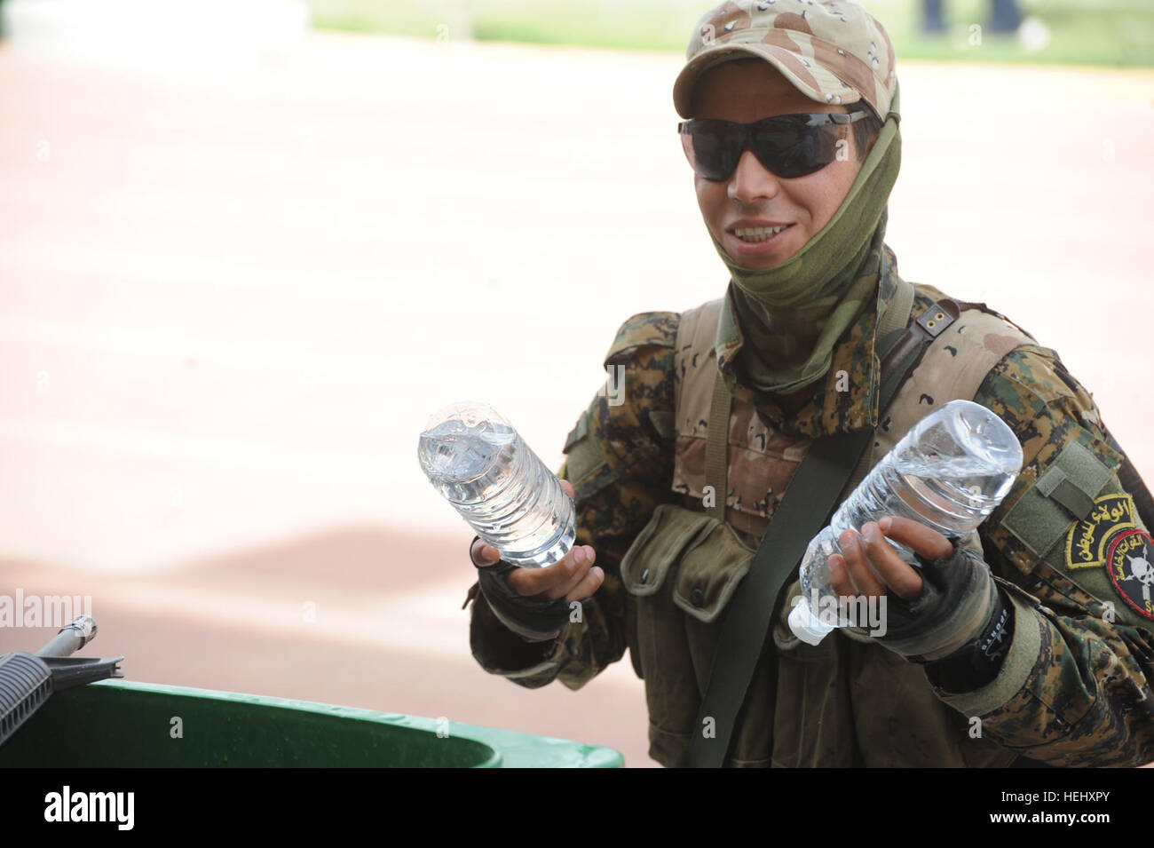 An Iraqi Soldier grabs bottles of cold water during a tournament game ...