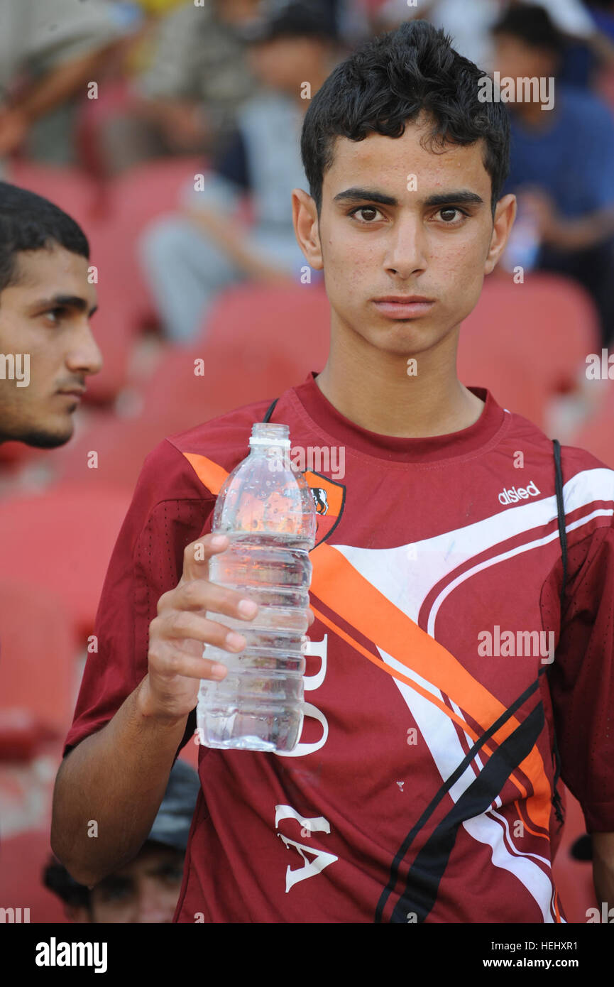 An Iraqi soccer fan enjoys a cold bottle of water during a tournament ...