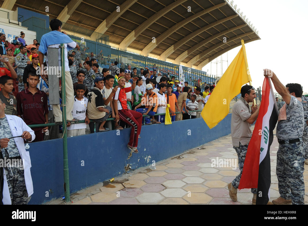 Iraqi national policemen, and members of the Iraqi public watch the ...